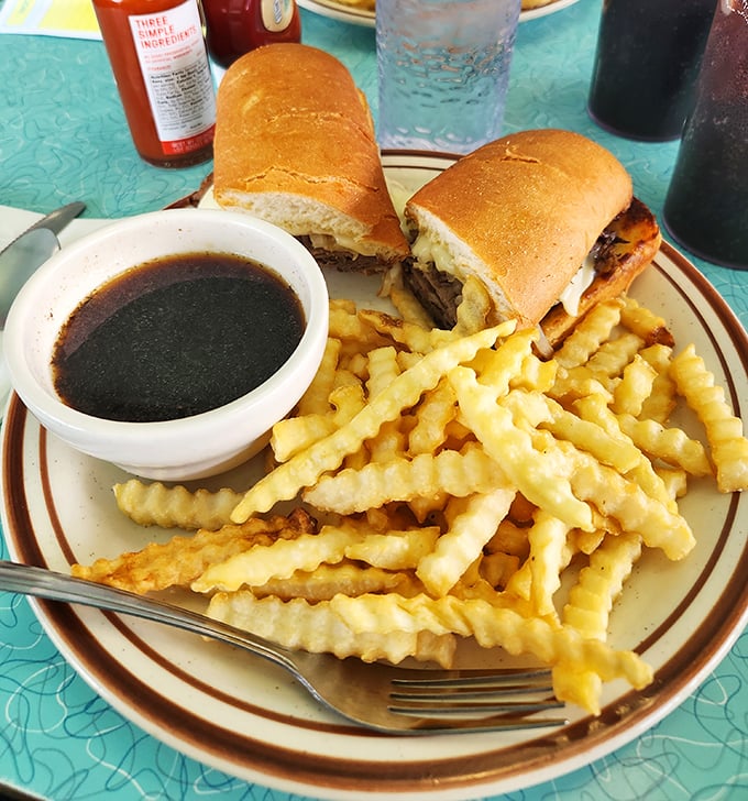 The French Dip sandwich with its side of savory au jus isn't just lunch – it's an interactive eating experience that rewards proper dipping technique.