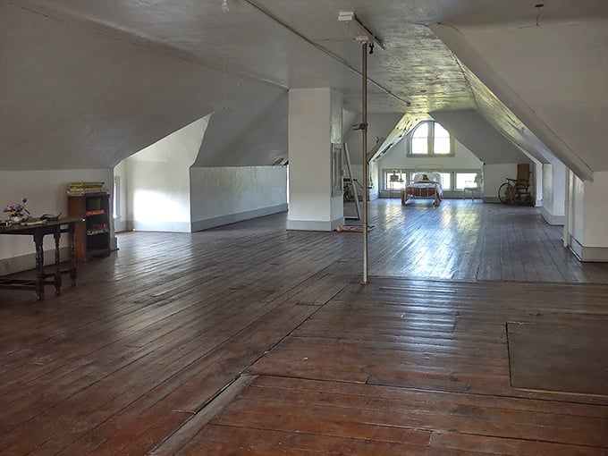 Sunlight streams through attic windows, illuminating wide-planked floors where footsteps – both visible and invisible – have tread for generations.