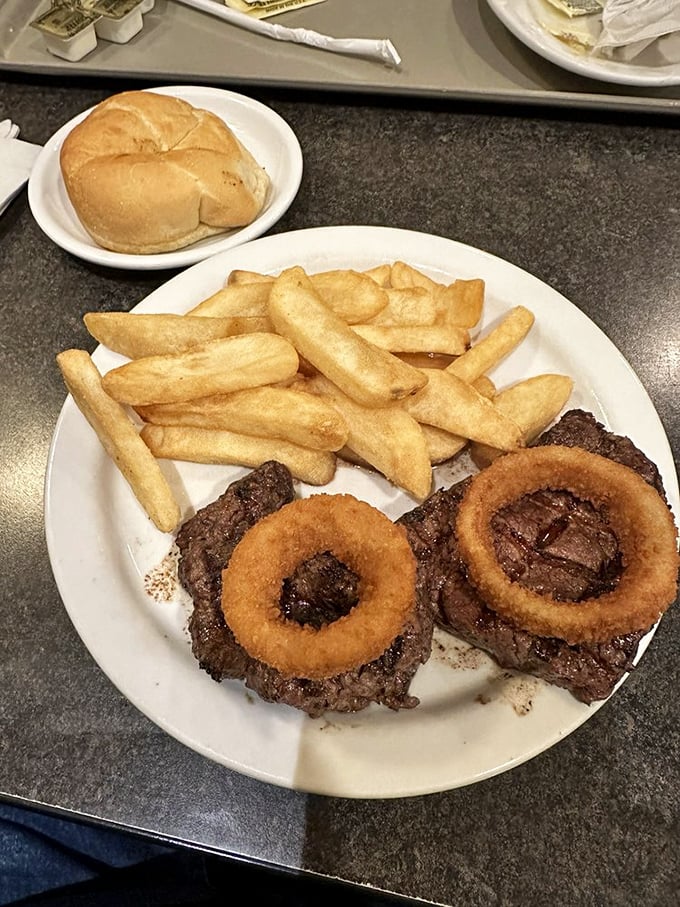 The steak and onion rings platter—where beef meets its crispy circular companions in a relationship your cardiologist warned you about.
