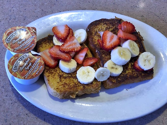 French toast that doesn't just say "good morning"—it sings it with fresh strawberries, banana slices, and a dusting of powdered sugar.