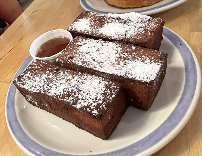 French toast sticks that would make your childhood self high-five your adult self. The powdered sugar snowfall is just showing off.