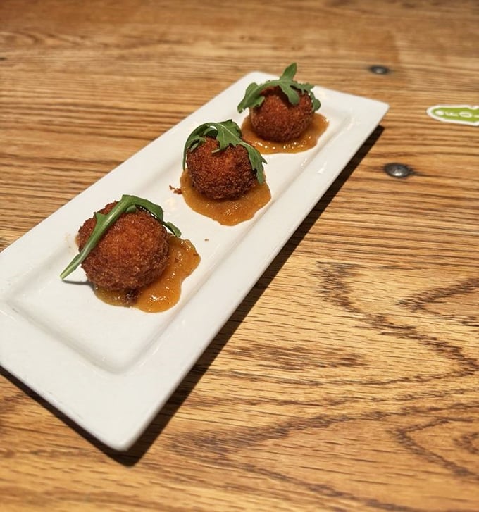 These aren't just any fried balls—they're crispy grits transformed into golden orbs of Southern comfort, each one a perfect three-bite journey.