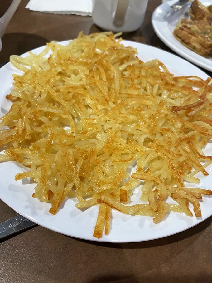 Hash browns achieving that perfect golden-brown crispiness level that makes you wonder why anyone ever invented the fork instead of just using hands.