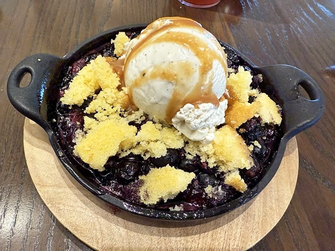 A berry cobbler that doesn't just end the meal—it provides the exclamation point, with ice cream melting into warm fruit like a sweet summer sunset.