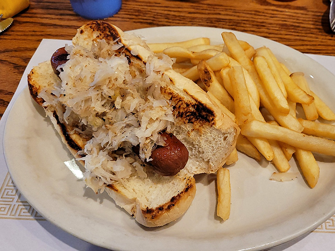 A hot dog nestled in a toasted bun with a mountain of sauerkraut—proof that simple pleasures are often the most satisfying.