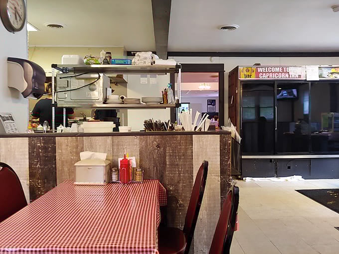 The kitchen pass reveals the organized chaos where burger magic happens—handwritten tickets and plates lined up like soldiers awaiting deployment.
