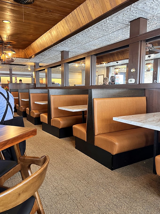 Those caramel-colored booths aren't just seating—they're front-row tickets to the greatest show on earth: breakfast in America.