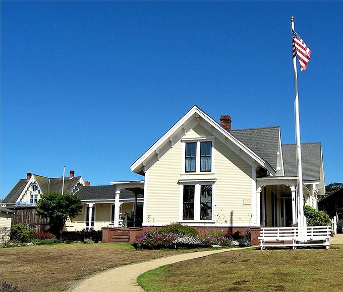 The Kelley House Museum stands proudly with its American flag, preserving stories of lumber barons and artists who shaped this coastal haven.