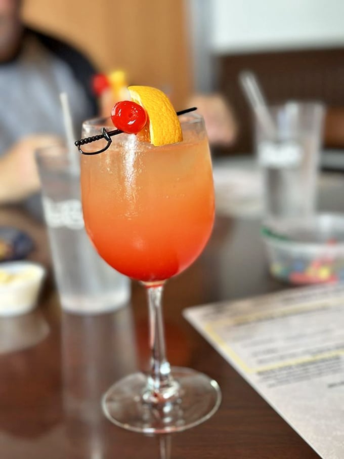 Sunrise in a glass! This vibrant cocktail with its cherry garnish isn't just a drink – it's the official announcement that vacation mode has begun.