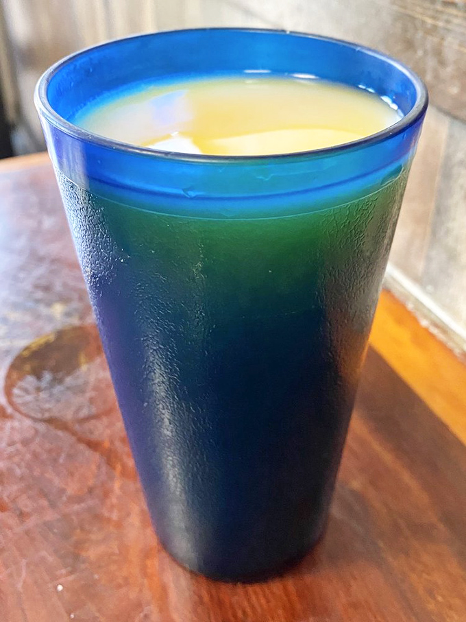 That distinctive blue glass—a Sugar Shack signature—filled with what appears to be orange juice. Morning sunshine in liquid form.