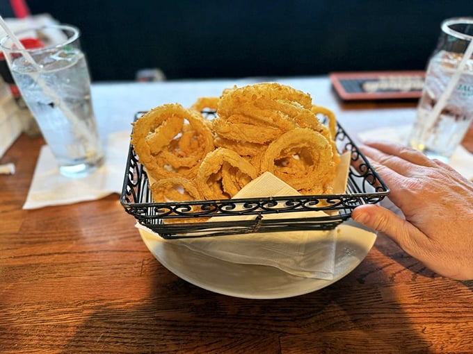 Onion rings engineered for maximum crunch—the perfect golden circles that make you wonder why anyone bothers with lesser side dishes.