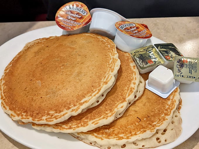 Pancakes stacked higher than your weekend expectations, golden-brown and ready for their maple syrup baptism.