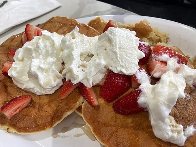 Strawberry pancakes with whipped cream that don't just say "good morning"—they practically sing it in four-part harmony.