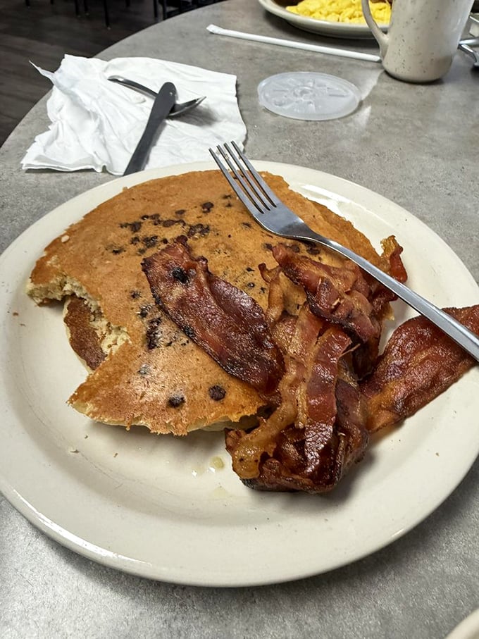 The pancake-bacon alliance has never looked stronger—a perfect partnership of sweet and savory that makes waking up before noon entirely worthwhile.