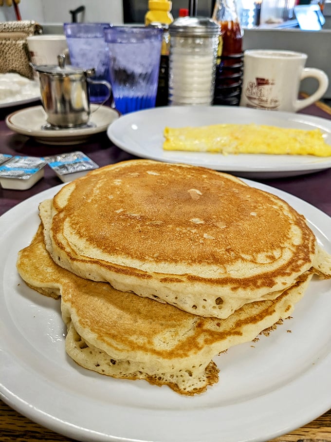 Pancakes so fluffy they could double as pillows. The perfect canvas for rivers of syrup and butter—breakfast architecture at its finest.
