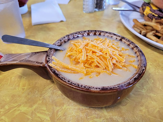 A bowl of potato soup topped with shredded cheddar—comfort that arrives by spoon and warms you from the inside out.