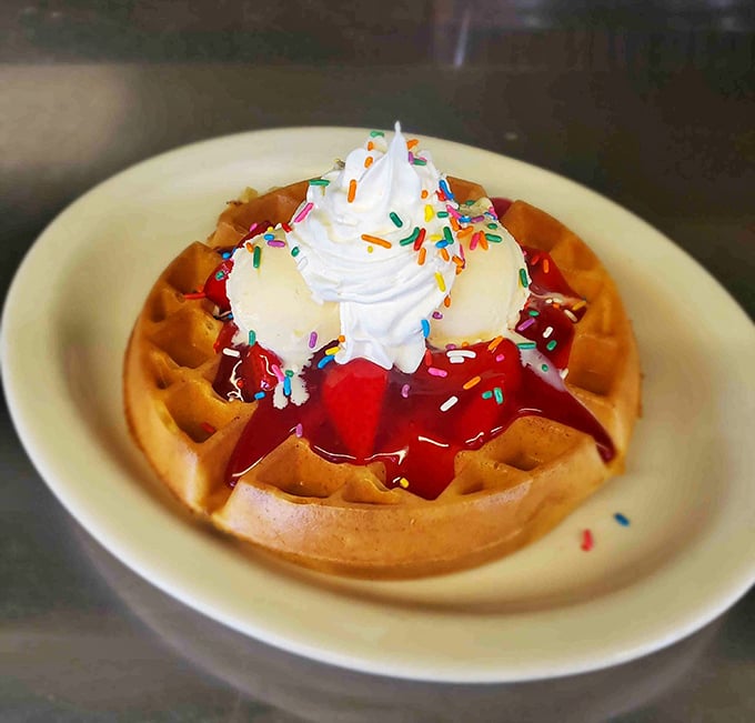 A rainbow waffle topped with strawberries and whipped cream – because breakfast should always include a little magic.