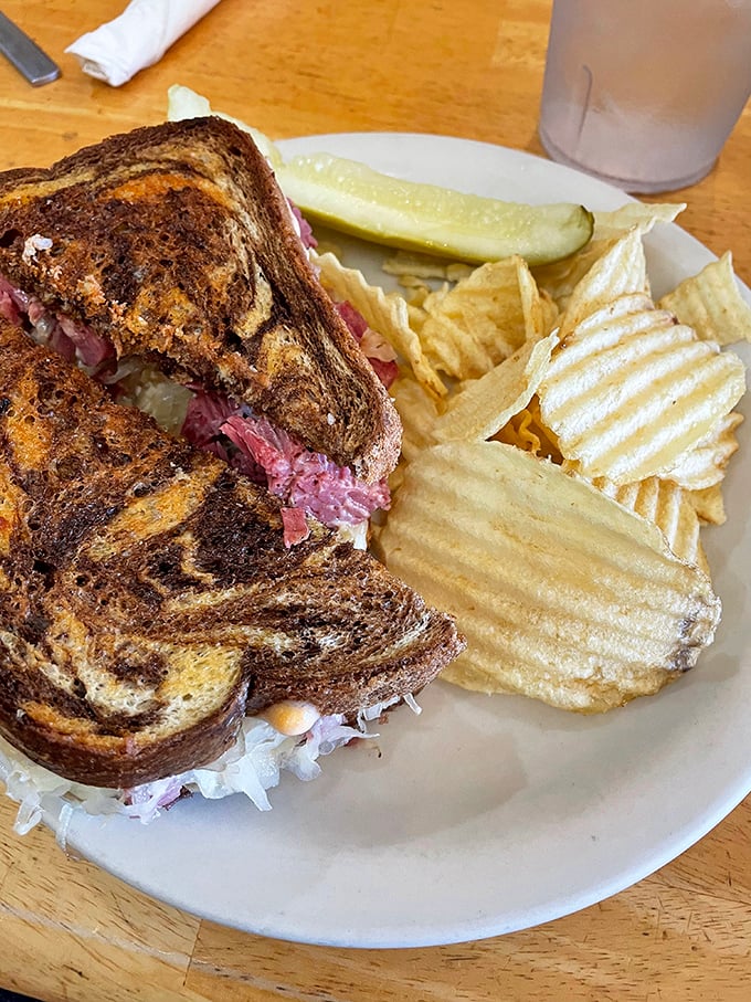 A Reuben sandwich with personality – the marble rye toasted to perfection, the corned beef peeking out like it's playing hide and seek.
