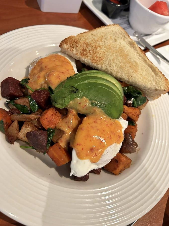 A colorful landscape of roasted vegetables supporting poached eggs like thrones, with avocado adding that creamy California accent to Wisconsin's morning.