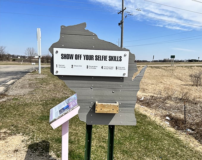 Wisconsin's roadside marketing genius: a state-shaped sign inviting travelers to "Show Off Your Selfie Skills" with their rosy resident.