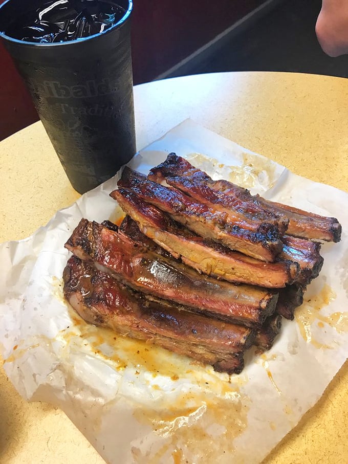 A slab of ribs with sweet tea—the kind of lunch that makes you reconsider your afternoon plans.
