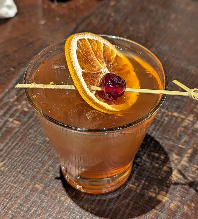 The Smoked Old Fashioned – where bourbon meets barbecue philosophy in liquid form, garnished with a perfect orange slice and cherry.