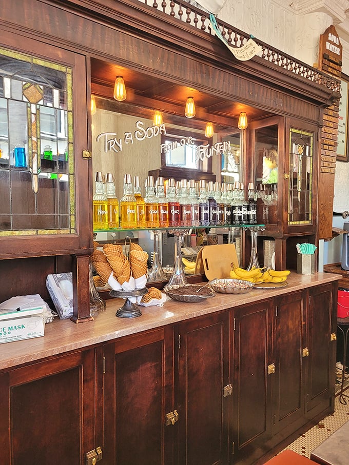 The vintage soda fountain doesn't just serve drinks—it serves time travel in a glass, complete with syrups lined up like liquid jewels waiting to transform ordinary water. 