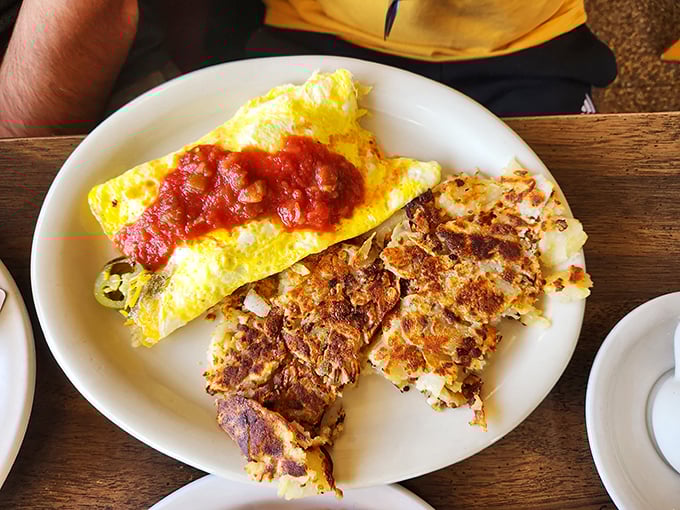 An omelet that's been folded around its fillings like a warm, eggy hug. The home fries aren't a side dish—they're an essential supporting character.