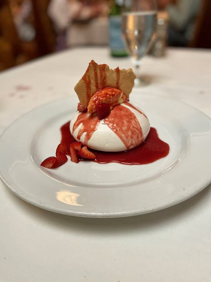 This isn't just dessert; it's architecture – a delicate pavlova crowned with fresh berries that shatters with each spoonful like sweet, edible glass.