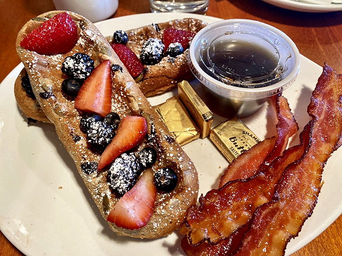 These aren't your ordinary waffles—they're superfood canvases painted with berries, dusted with powdered sugar, and accompanied by bacon because balance.