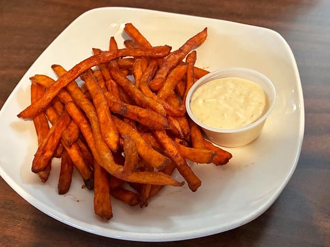 Sweet potato fries with a golden hue that would make King Midas jealous, paired with a dipping sauce that transforms "just one more" into an empty plate.