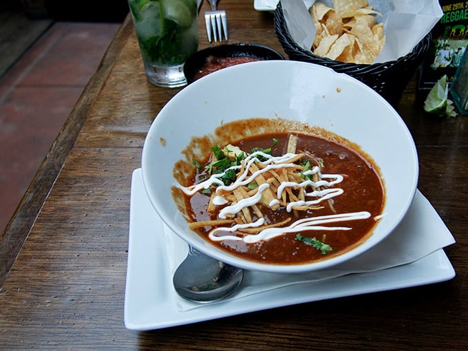 This tortilla soup isn't just served—it's presented with artistic drizzles of crema that turn comfort food into a bowl of Mexican expressionism.