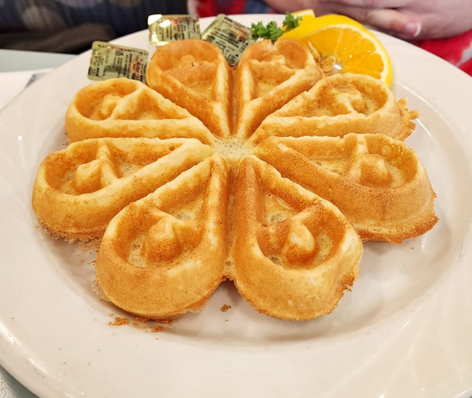 The golden flower-shaped waffle isn't just breakfast—it's edible morning sunshine that makes syrup application a strategic art form.