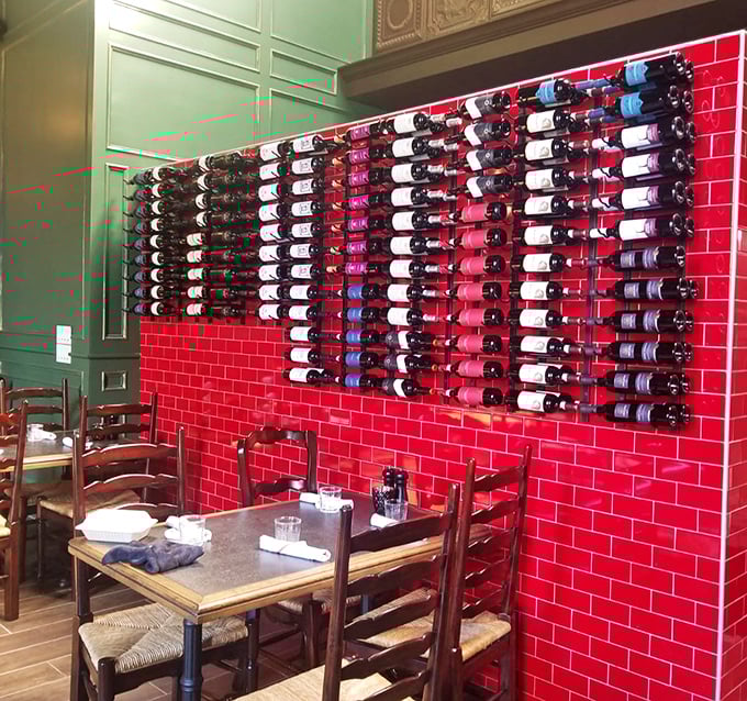 Wine bottles line the vibrant red wall like soldiers guarding the gates to flavor town. Italian vintages ready for your selection.