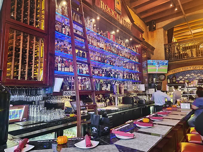 The bar's impressive wall of spirits requires its own zip code. That ladder isn't decoration—it's necessary equipment for cocktail excellence.