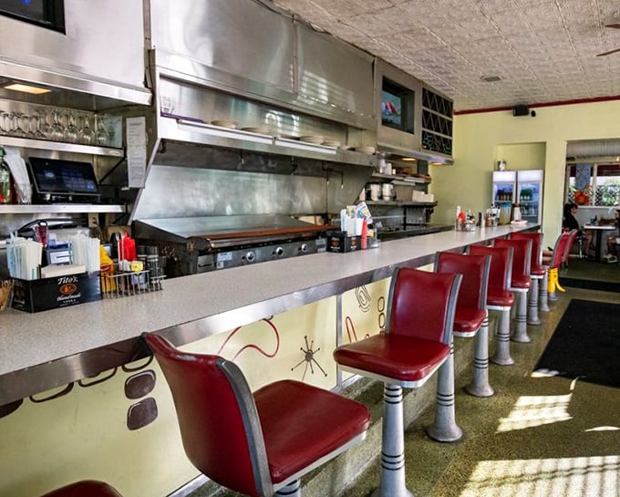 The counter seating with its cherry-red stools isn't just a place to eat – it's theater seating for the culinary show happening behind the grill.