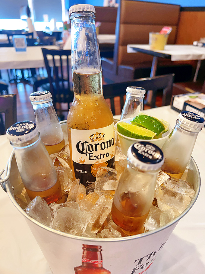 Cold beers nestled in ice, waiting to extinguish the pleasant fire of Cajun spices. The lime wedges aren't just garnish—they're essential flavor companions.