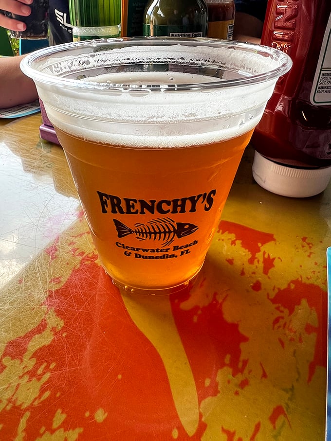 A cold beer in a Frenchy's cup—because sometimes the perfect beverage pairing isn't complicated, it's just refreshingly right.