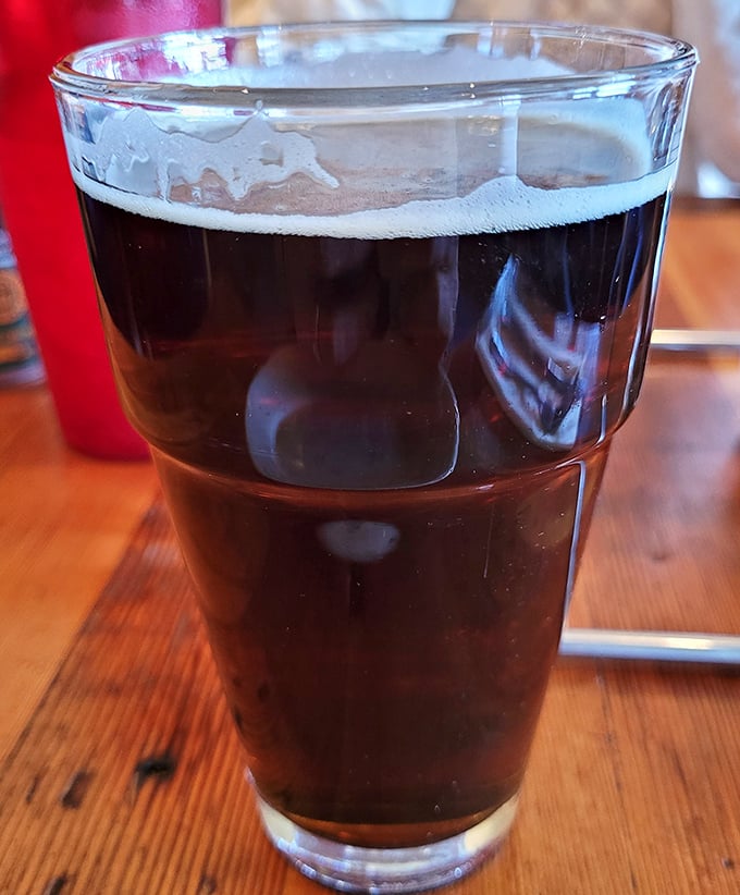 A proper pint of dark beer—because pizza this good deserves a worthy liquid companion on your flavor journey.