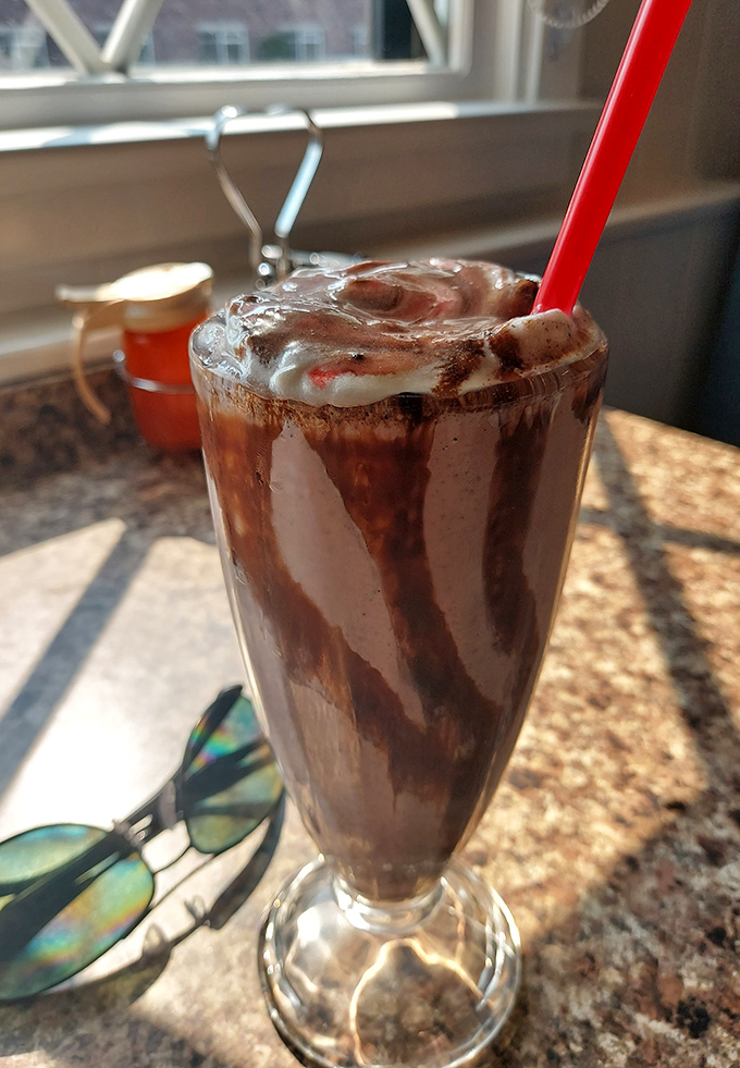 This chocolate milkshake isn't just thick—it's contemplating a career in solid geometry. The straw stands at attention like a soldier.