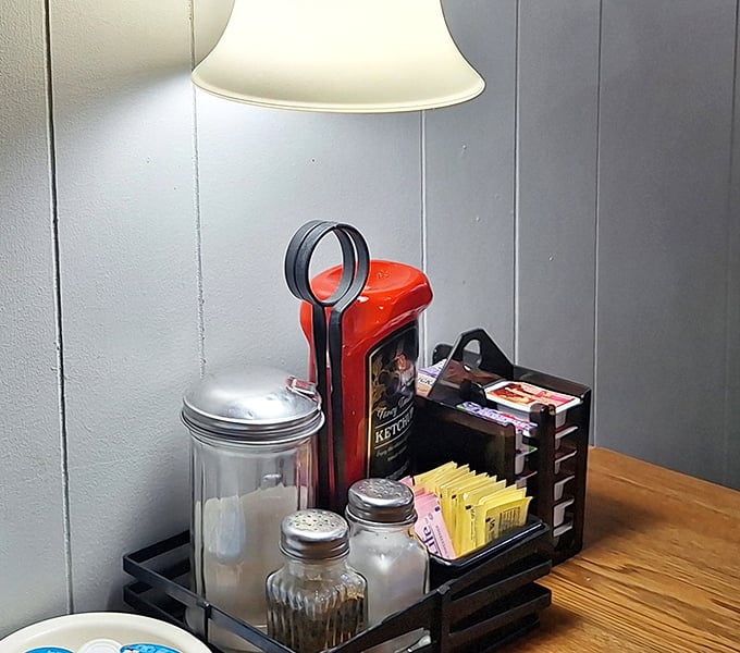 The condiment caddy—that humble diner centerpiece where sugar packets, salt, pepper, and ketchup stand ready for duty.