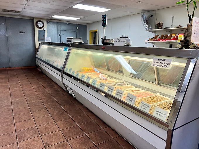 The seafood counter—where tomorrow's dinner swims today. A glass case of possibilities that makes grocery store seafood departments weep with inadequacy.