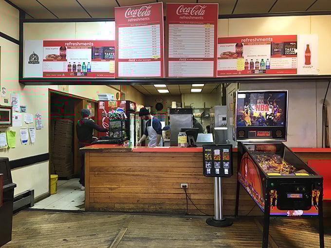 The ordering counter—where dreams are placed and hunger pangs go to die, all under the watchful gaze of Coca-Cola signage.