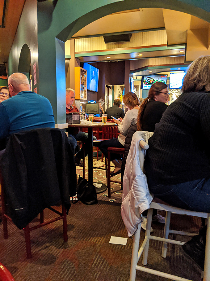 A bustling evening at Grotto where strangers become neighbors over shared food experiences. The colorful archway frames more than just the room—it frames memories.