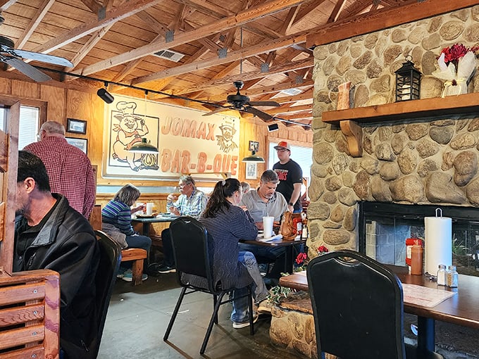 The dining room hums with the universal language of good eating. That stone fireplace isn't just for show – it's the heart of this BBQ sanctuary.