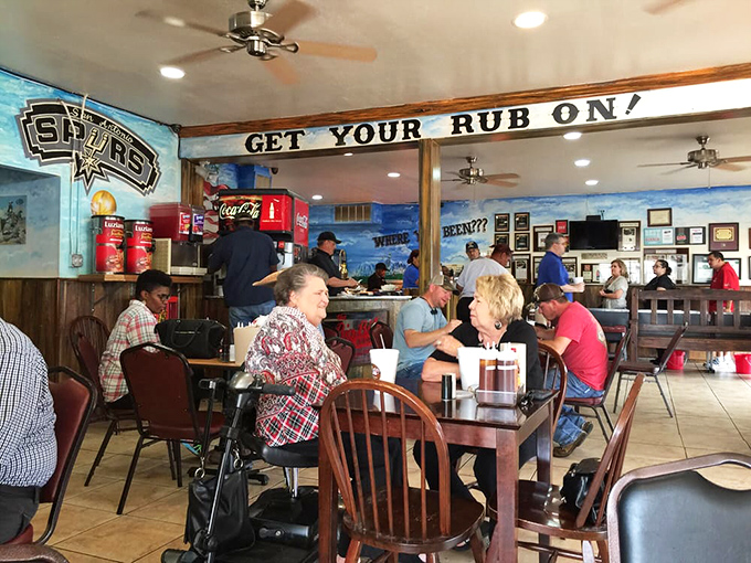 The "Get Your Rub On" sign isn't just decor—it's life advice. These diners aren't just eating; they're participating in a time-honored Texas ritual.
