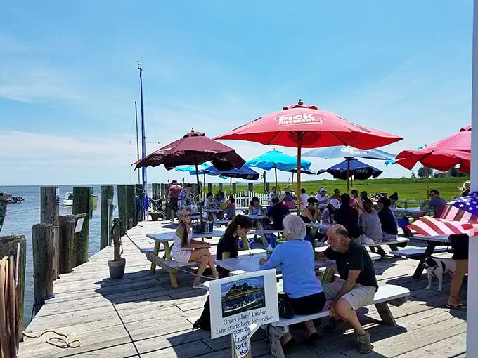 Waterfront dining at its most democratic – colorful umbrellas, simple tables, and the shared joy of fresh seafood by the harbor.