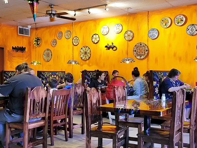 The dining room hums with the universal language of good food—colorful plates against warm yellow walls creating a canvas for culinary memories.