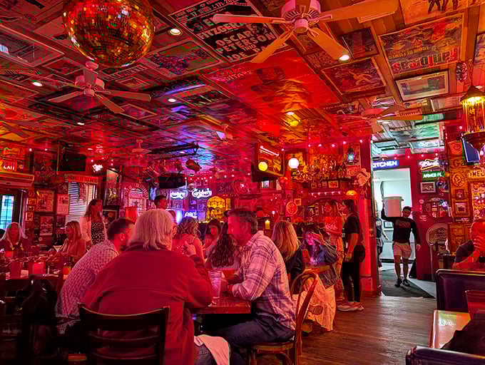 The crimson glow bathes diners in flattering light while the ceiling's collage of memorabilia provides endless conversation starters between bites.