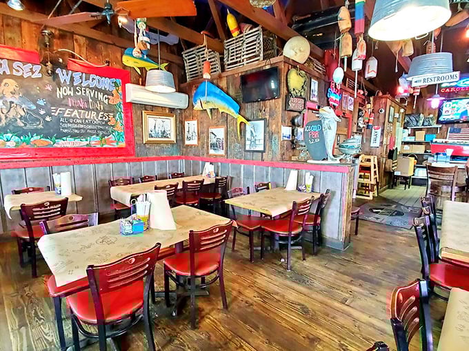 Red chairs against weathered wood planks – where countless seafood stories have been shared over hushpuppies and cold beer.